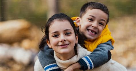 가을 공원에서 그녀의 남동생과 함께 걷고 노는 아름다운 십 대 소녀 피기 백 라이드 사진 Unsplash의 바깥 이미지