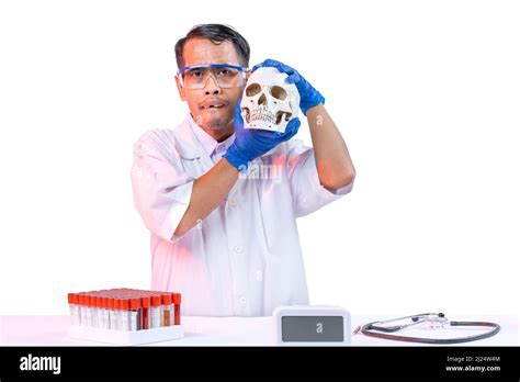Asian Nerd Scientist Standing And Holding A Skull Head With A Stethoscope And Medical Tube Rack