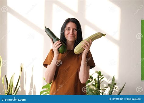 A Young Girl Holds Two Zucchini In Her Hands Stock Image Image Of