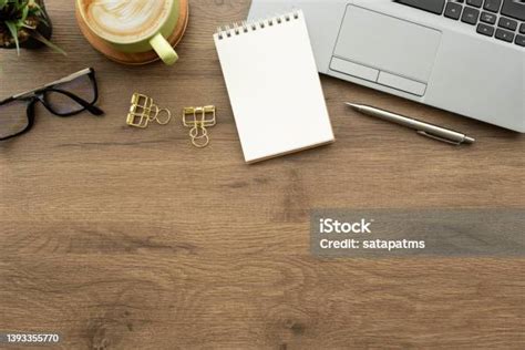 작은 빈 메모 책은 라떼 커피와 사무용품 한 잔과 함께 나무 사무실 책상 테이블 위에 노트북 컴퓨터 위에 있습니다 복사 공간이있는 상단보기 평평한 누워 0명에 대한 스톡