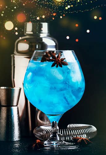 바텐더 철강 도구 블랙 바 카운터 배경 선택적 초점 큰 와인 유리에 삼 부 카 리큐 어 레몬 주스 분쇄 얼음과 아니 스 별과 블루 알콜 칵테일 0명에 대한 스톡 사진 및