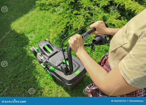 Woman Cutting Grass With Lawn Mower In Garden On Sunny Day Closeup