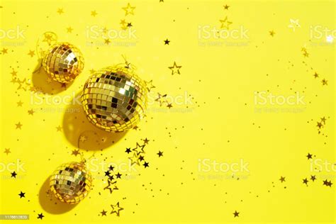 창조적 인 크리스마스 개념입니다 노란색 배경 위에 빛나는 골드 디스코 공입니다 플랫 레이 상단 보기 새해 장식 별이 반짝입니다 파티 시간입니다 인사말 카드 2020년에 대한