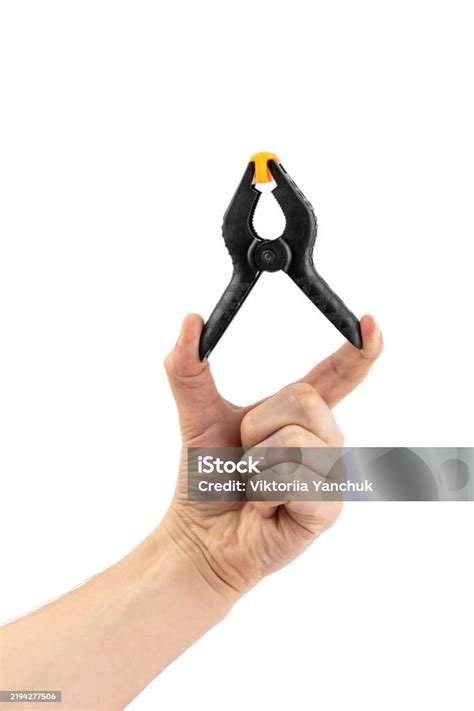 흰색 배경에 클로즈업 남자의 손은 주황색 자물쇠가 달린 큰 플라스틱 검은 클램프 일상 생활의 도구 안정적인 고정 수리 도구를