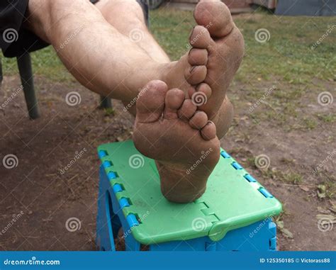 Dirty Bare Feet Of A Sleeping Person Showing Out Of The Blanket Stock
