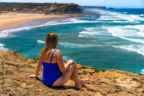 Beautiful Mature Woman In Swimsuit Sitting And Sunbathing On Cliff Near Sunny Beach Monte