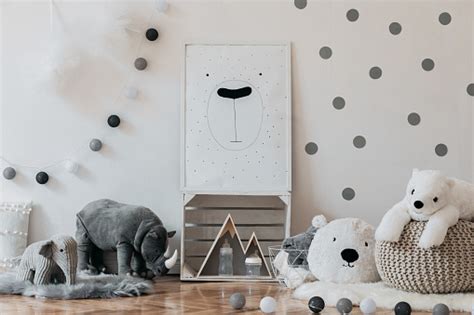 모의 패턴 벽 상자 테 디 베어와 장난감에 사진 포스터 프레임을 가진 세련 된 스 칸디 나 비아 아이 방 흰 벽 나무 액세서리와 화려한 장난감 놀이방의 귀여운 현대적인