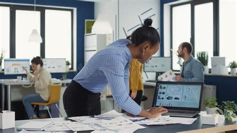 busy african american in startup putting clipboard on desk looking at