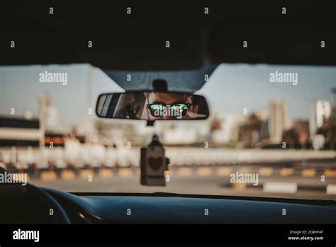 Caucasian Male Wearing Sunglasses Looking At The Rear View Mirror Stock Photo Alamy