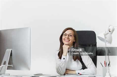 아름 다운 미소 브라운 헤어 비즈니스 여자 양복과 안경 책상에 앉아 현대 모니터 빛 사무실에서 문서를 컴퓨터에서 작업 보고 카메라 흰색 배경 경영자에 대한 스톡 사진 및