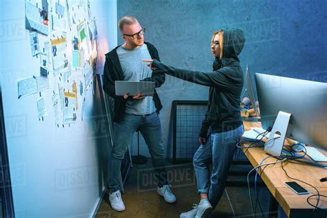 Couple Of Hackers Working On Malware Together In Dark Room Royalty