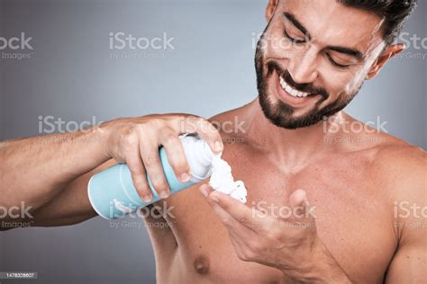 손 면도 크림 제모를 위해 회색 배경에 격리된 스튜디오에 있는 제품을 가진 남자 스킨케어 얼굴 그리고 제모 건강 및 위생을 위해 면도할 페이셜 폼이 있는 행복한 남성 모델