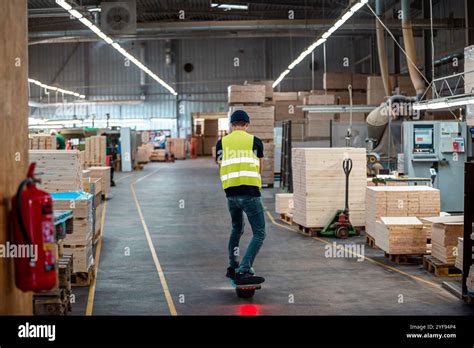 Modern Industrial Warehouse Logistics Worker Using An Electric Personal Transporter To Navigate