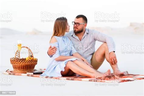 사랑 스러운 매력적인 부부는 화이트에 함께 앉아 모래 해변 해변에서 피크닉을 즐기는 행복 한 부부와 여름 휴가에 좋은 시간을가지고 2명에 대한 스톡 사진 및 기타 이미지