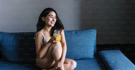 멕시코 라틴 아메리카의 집에서 소파에서 쉬는 동안 오렌지 주스를 마시는 라틴 여자 사진 Unsplash의 라틴 아메리카 및 히스패닉 문화 이미지