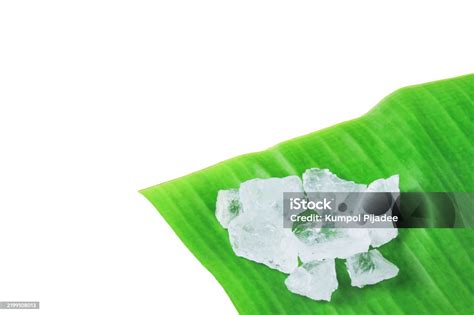 흰색 배경에 녹색 바나나 잎에 명반 돌 조각 천연 미네랄과 식물 기반 성분 사이의 연결에 대한 개념은 전통적인 관행과 전체론적 웰빙입니다 0명에 대한 스톡 사진 및 기타