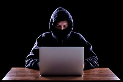 premium photo computer hacker stealing data from laptop