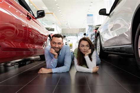Young Married Couple Lying On The Floor Fooling Around In A Car