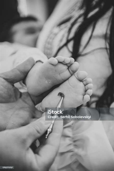 아기의 세례식 작은 아기 발의 클로즈업 세례성사 대모는 아이를 품에 안고 있다 사제는 손을 아이의 다리에 갖다 댄다 사원 정교회 흑백 사진입니다 3 명에 대한 스톡 사진 및