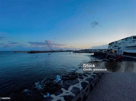 Small Foamy Waves Hitting A Wall By The Coastline Captured In The