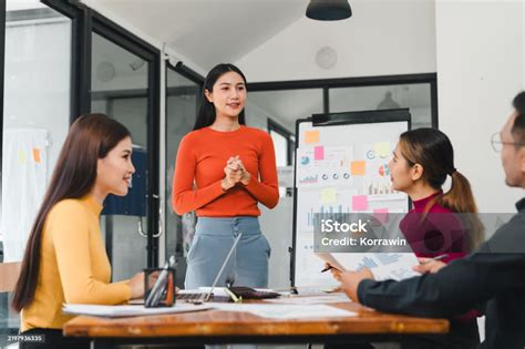 현대 사무실에서 동료들에게 데이터를 발표하는 여성과의 비즈니스 회의 팀은 프레젠테이션 보드에서 전략을 논의하고 차트를 분석하면서 참여합니다 25 29세에 대한 스톡 사진 및