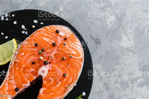 어두운 돌 배경에 향신료와 신선한 생 연어 생선 스테이크 물고기 상단보기 플랫 레이 모형 오버 헤드로 만든 창조적 인 레이아웃 건강한 음식 개념 건강한 식생활에 대한 스톡