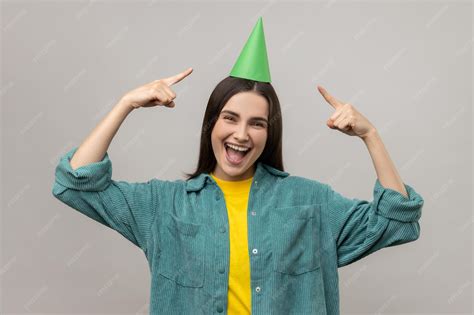 Mujer Señalando El Cono De Fiesta En La Cabeza Y Sonriendo A La Cámara