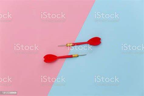 분홍색 파란색 파스텔 배경에 금속 팁이있는 두 개의 빨간 플라스틱 다트 맨 위 보기입니다 플랫 레이 미니멀리즘 겨냥에 대한 스톡 사진 및 기타 이미지 Istock