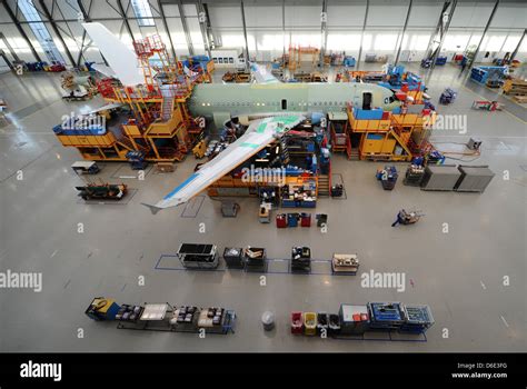 Skilled Personnel Work On Aircraft At The A320 Final Assembly Hangar At
