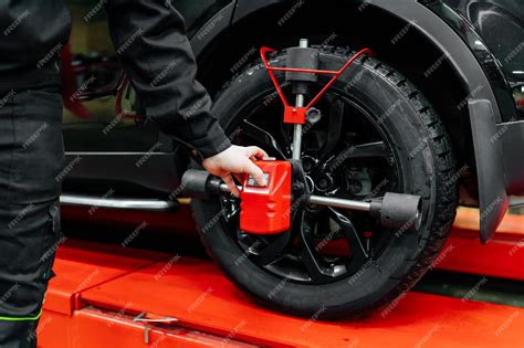 Premium Photo | Car mechanic installing wheel alignment sensors