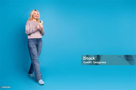 사랑 스런 고위 숙녀 산책 홀드 가제트 옷을 입은 세련된 회색 의류 파란색 배경에 고립 된 전신 사진 50 54세에 대한 스톡 사진 및 기타 이미지 Istock