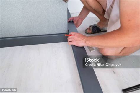 마스터는 절단을위한 주각의 길이를 측정하여 벽 모서리에 주각을 설치합니다 가사 집안일에 대한 스톡 사진 및 기타 이미지 가사 집안일 각도 굽도리 널 Istock