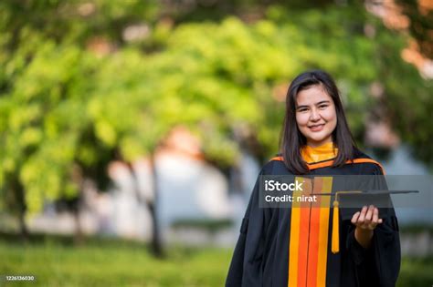 황금 가운을 입고 있는 한 여성 대학 졸업생이 졸업식 날 검은 모자를 쓰고 있다 교실에 대한 스톡 사진 및 기타 이미지 교실 교육 노랑 Istock