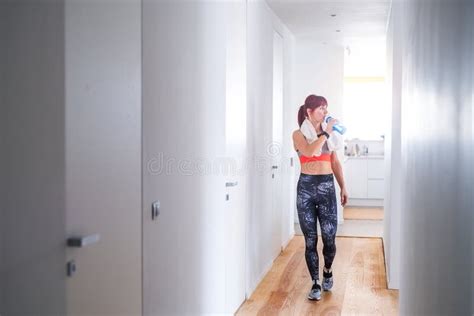 Beautiful Redhead Woman Drinking Water Resting After Home Fitness