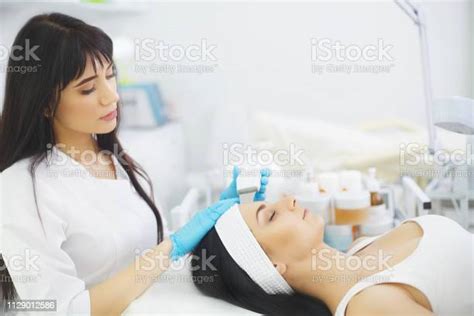 스킨 케어입니다 초음파 공동 현상 얼굴 필 링을 받고 하는 아름 다운 여자의 클로즈업 초음파 피부 클렌징 절차입니다 미용