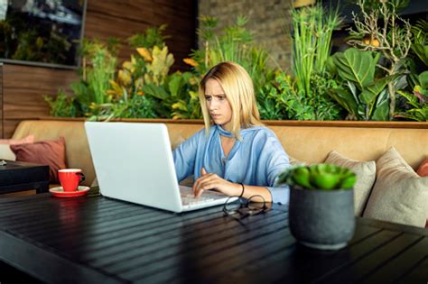 젊은 자신감 사업가 우아하게 옷을 입고 에스프레소 커피 한 잔과 사려 깊게 그녀의 노트북을보고 휴식입니다 20 24세에 대한