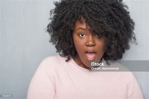 젊은 아프리카계 미국인 플러스 크기 여자 회색 그런 지 벽 입고 겨울 스웨터 두려워 하 고 놀라운 식 충격에 공포 하 고 얼굴을 흥분 가을에 대한 스톡 사진 및 기타 이미지