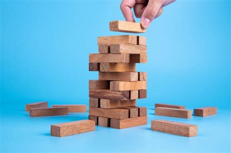 Premium Photo Hand Of Man Piling Up And Stacking A Wooden Block Plan