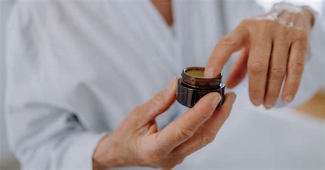 목욕 가운을 입은 아름다운 노인 여성은 욕실 스킨 케어 및 아침 루틴 개념에서 천연 얼굴 크림을 바르고 있습니다 사진 Unsplash의 슬로바키아 이미지