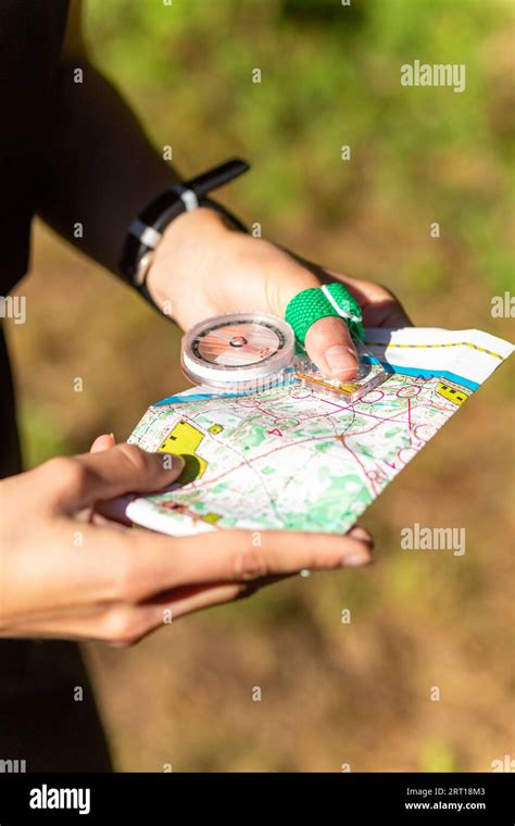 Woman Holding A Map And The Compass During Orienteering Competitions Athlete Uses Navigation