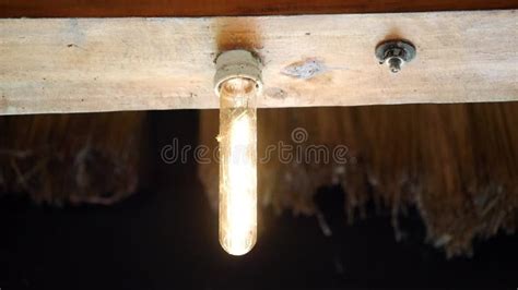 retro light bulb flickering on a wooden ceiling close up the light