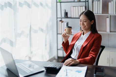 직장에서 컴퓨터와 재정 예산 문서를 사용하여 사업을 성공적으로 투자 한 행복한 미소 짓는 얼굴을 보여주는 여성 사업주의 초상화
