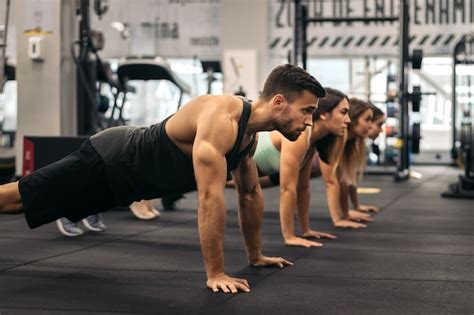 Premium Photo Group Of Young People Doing Push Ups In A Gym