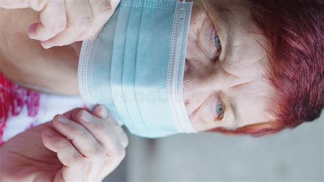 Vertical Screen Senior Woman Staying Safe And Putting On Medical Mask