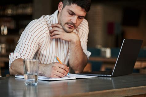 펜을 들고 프로젝트의 쓰기 단계 성인 남자는 낮에 카페에 앉아 원격 작업을 위해 노트북을 사용 25 29세에 대한 스톡 사진 및 기타 이미지 Istock