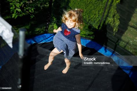 트램폴린에 점프 하는 작은 유치원 소녀 여름에 야외 활동과 재미를 행복한 재미있는 유아 아이 아이들을위한 스포츠와 운동 건강한