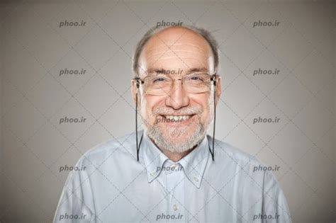 عکس با کیفیت مرد مسن با عینک و لبخند به لب در پس زمینه خاکستری عکس با