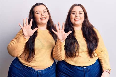 Young Plus Size Twins Wearing Casual Clothes Showing And Pointing Up