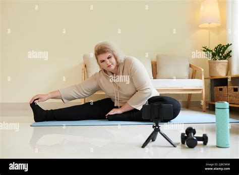 Plus Size Young Woman Repeating After Trainer While Watching Online