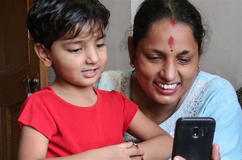 인도 소녀의 클로즈업 이미지는 여성의 손에 스마트폰으로 전화를 거는 어머니의 무릎 비디오 국내 방에서 Kameez 전통 의상을 입은 여성 헤드샷 전경에 초점 아이에 대한